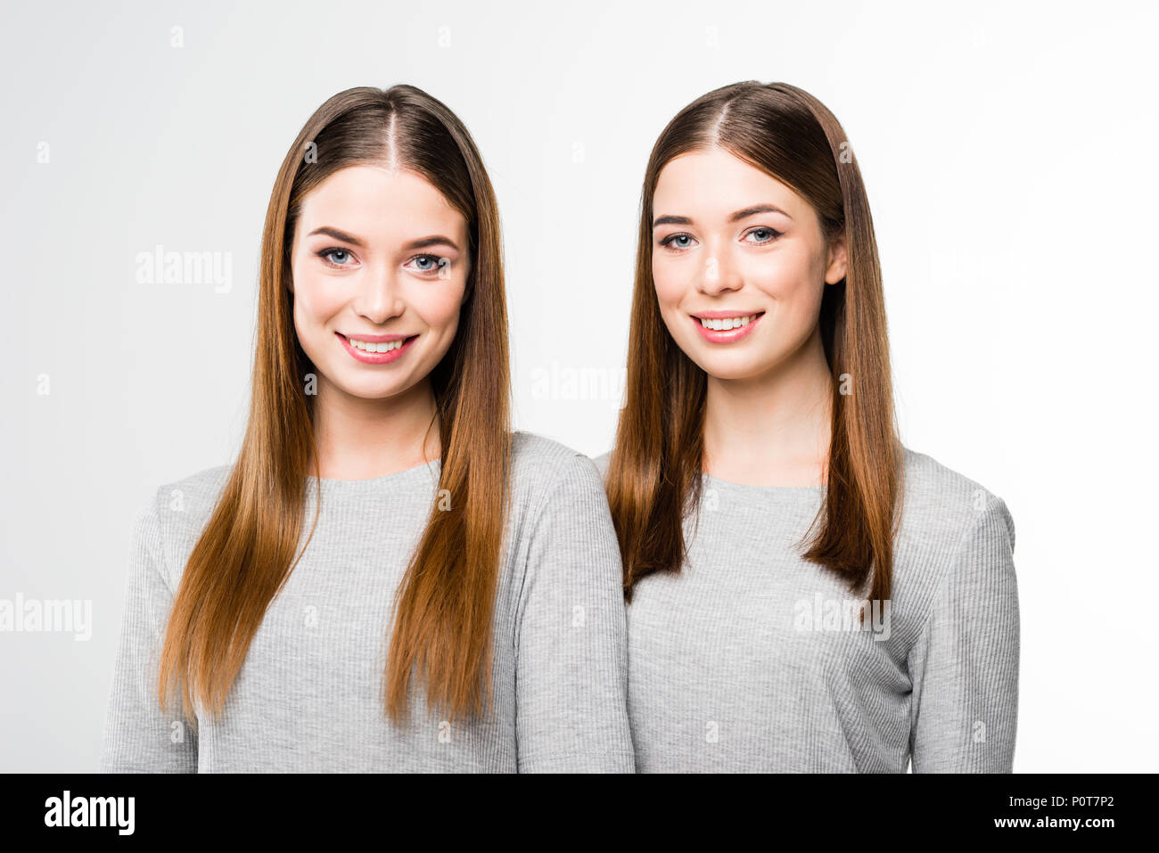 portrait of young smiling twins in grey tshirts looking at camera Stock ...