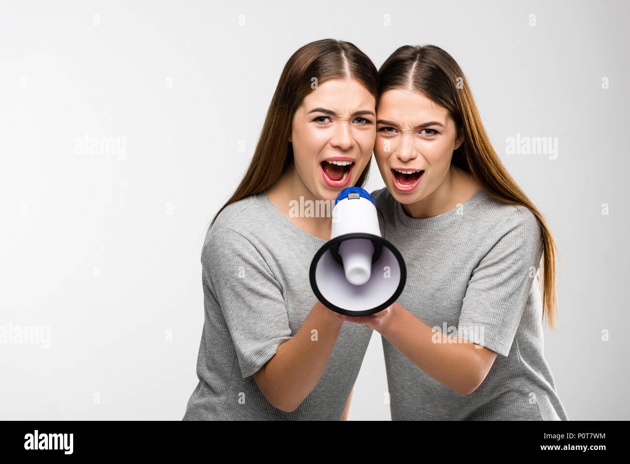 portrait of young twins screaming into loudspeaker in hands Stock Photo ...
