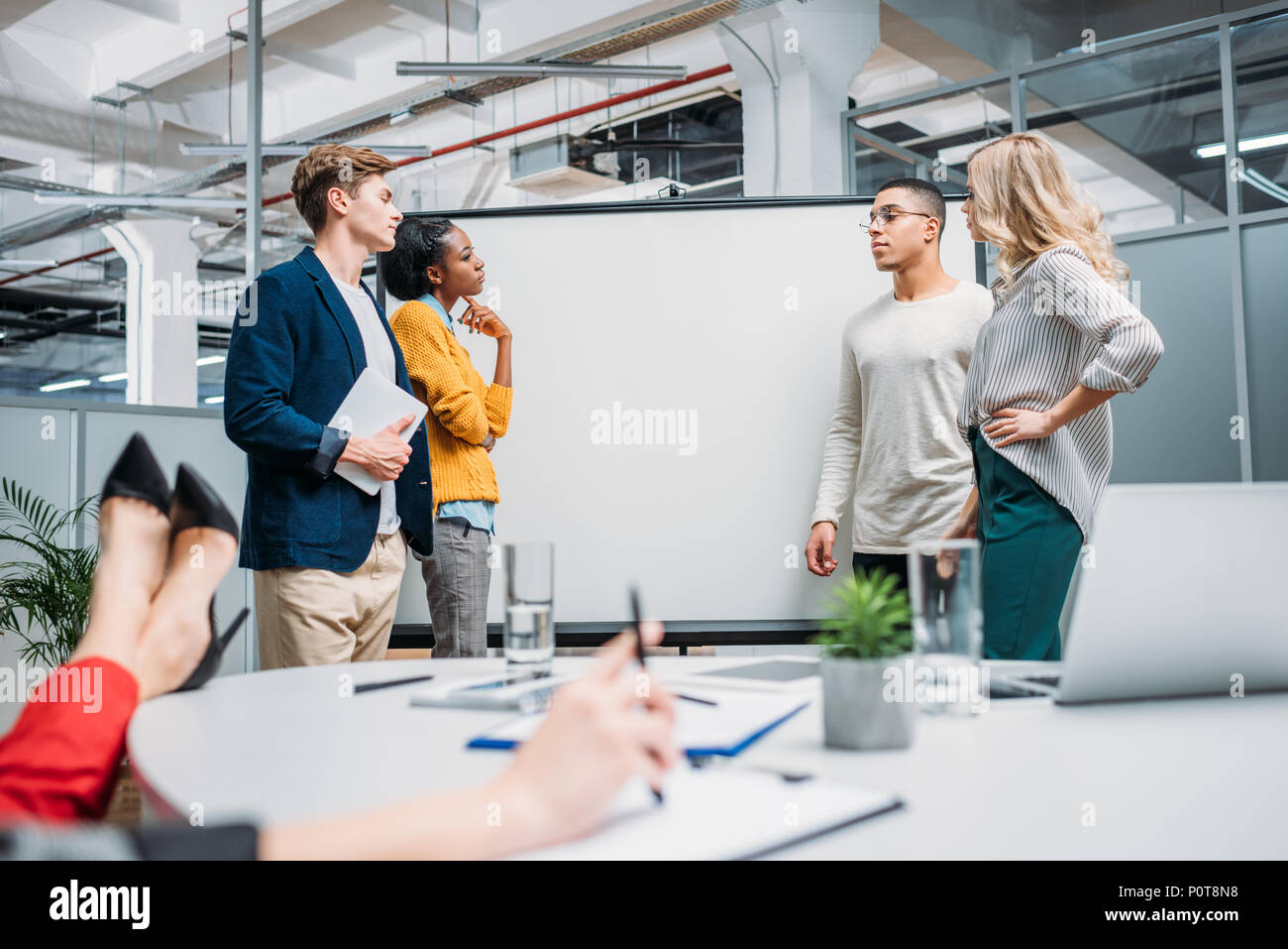 business partners standing in front of presentation board and having ...
