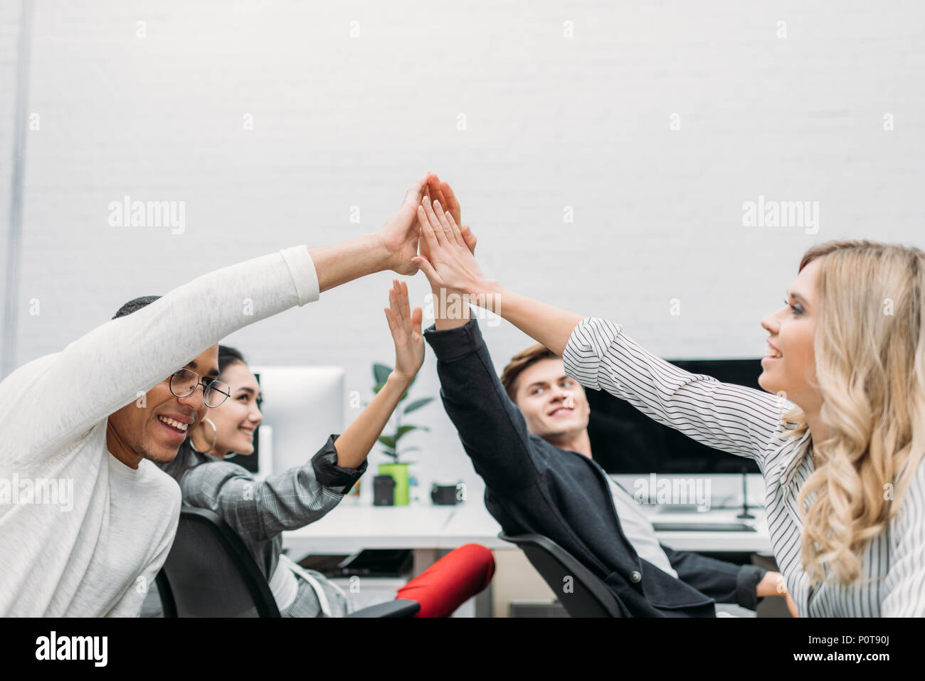 group of multiethnic business partners giving high five Stock Photo - Alamy