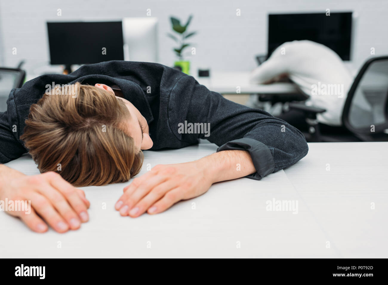 overworked young manager sleeping on work at modern office Stock Photo ...