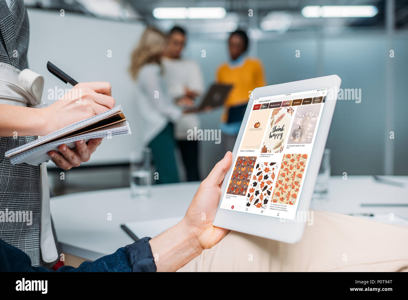 businessman holding tablet with pinterest on screen at modern office ...