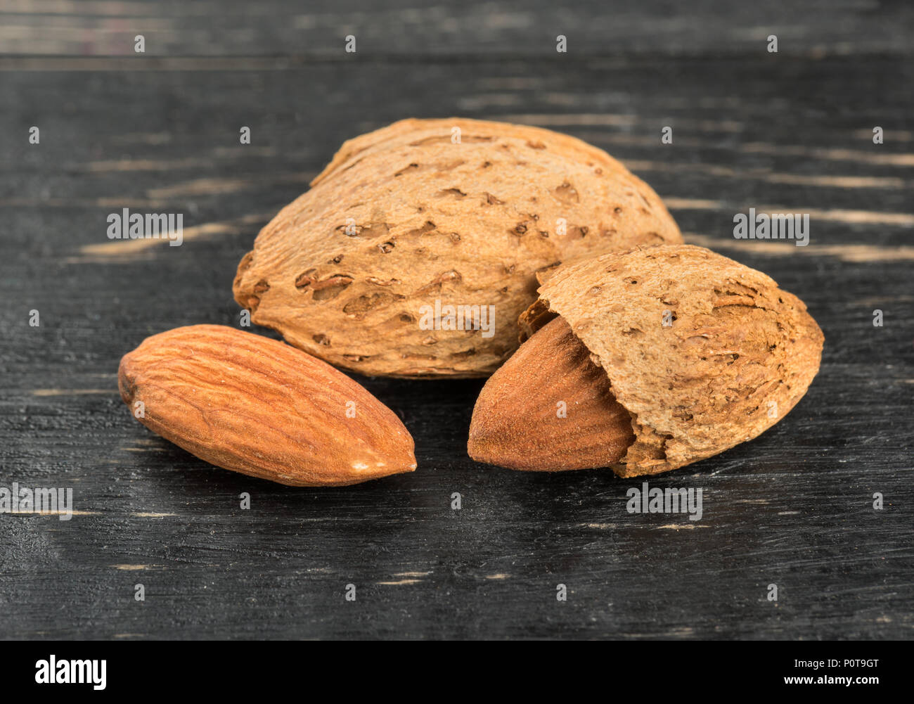 Dry almonds in their shells on a dark wooden background Stock Photo - Alamy