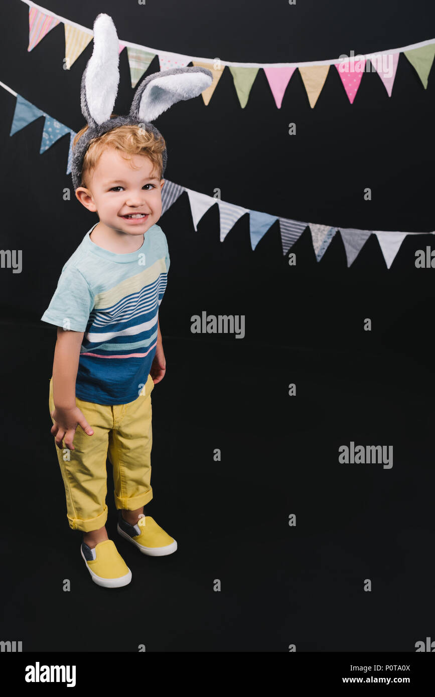 adorable little kid with bunny ears and garland smiling at camera on ...