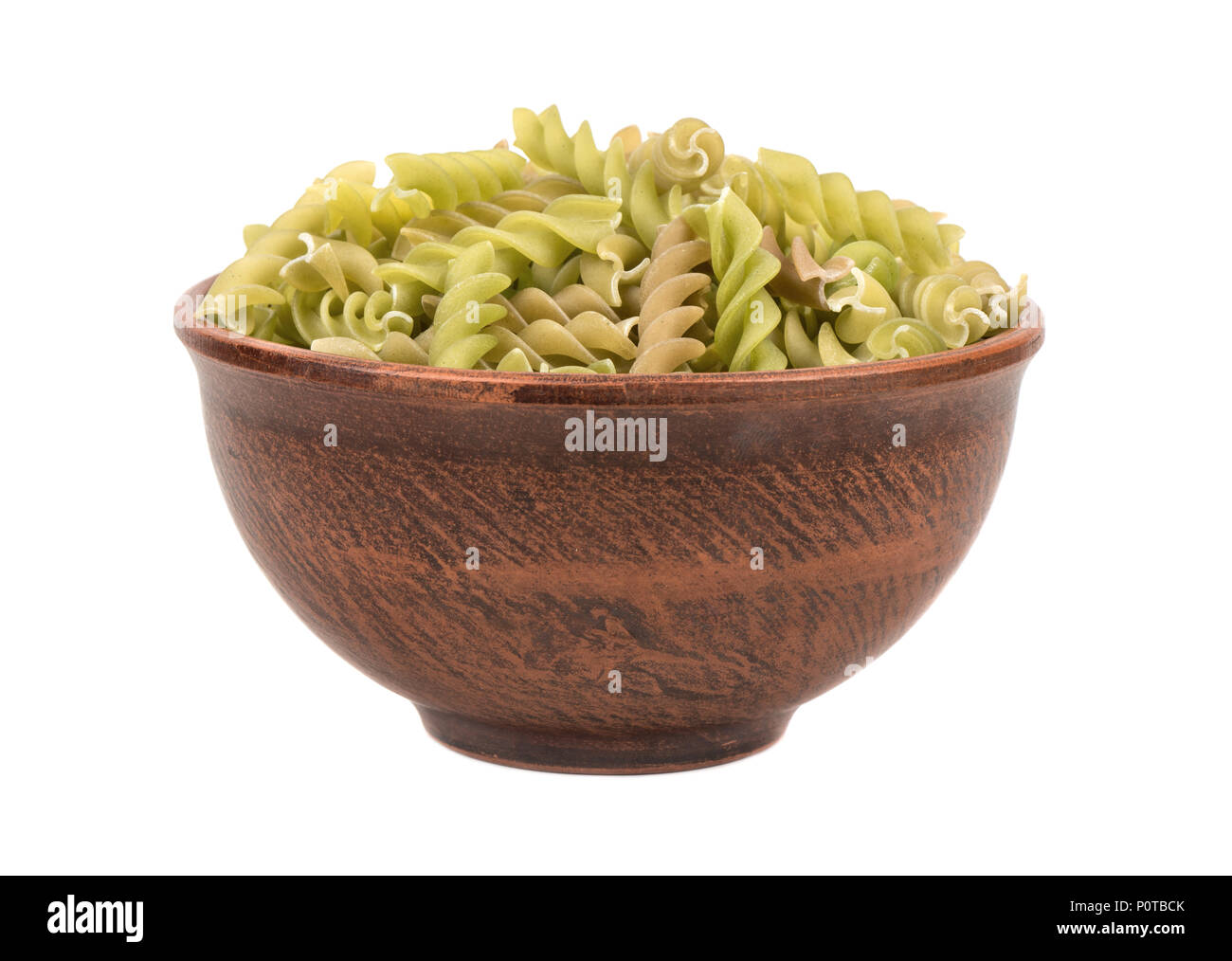 Green pasta fusilli in a bowl on white background Stock Photo - Alamy