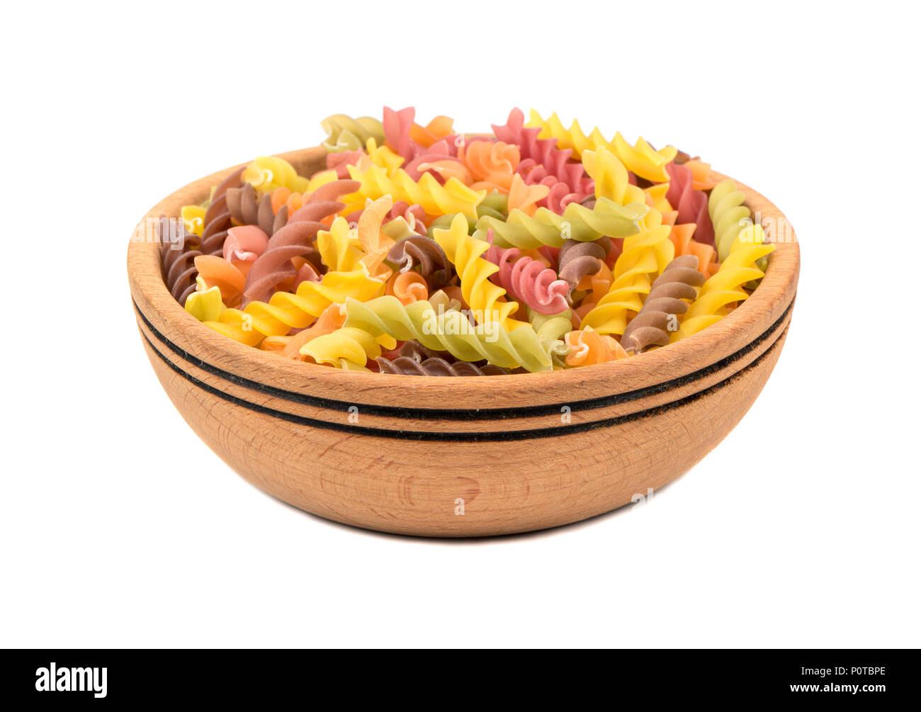 Colored pasta fusilli in a wooden bowl on white background Stock Photo ...
