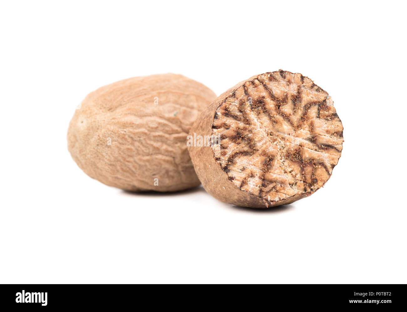 Nutmeg with half isolated on white background Stock Photo - Alamy
