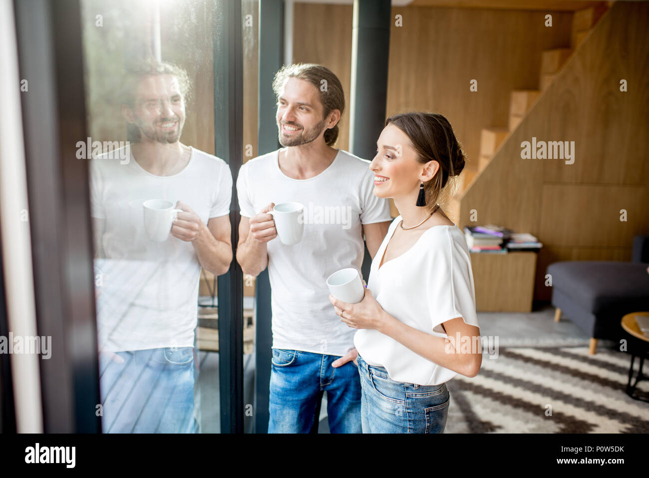 Family standing together at window hi-res stock photography and images ...