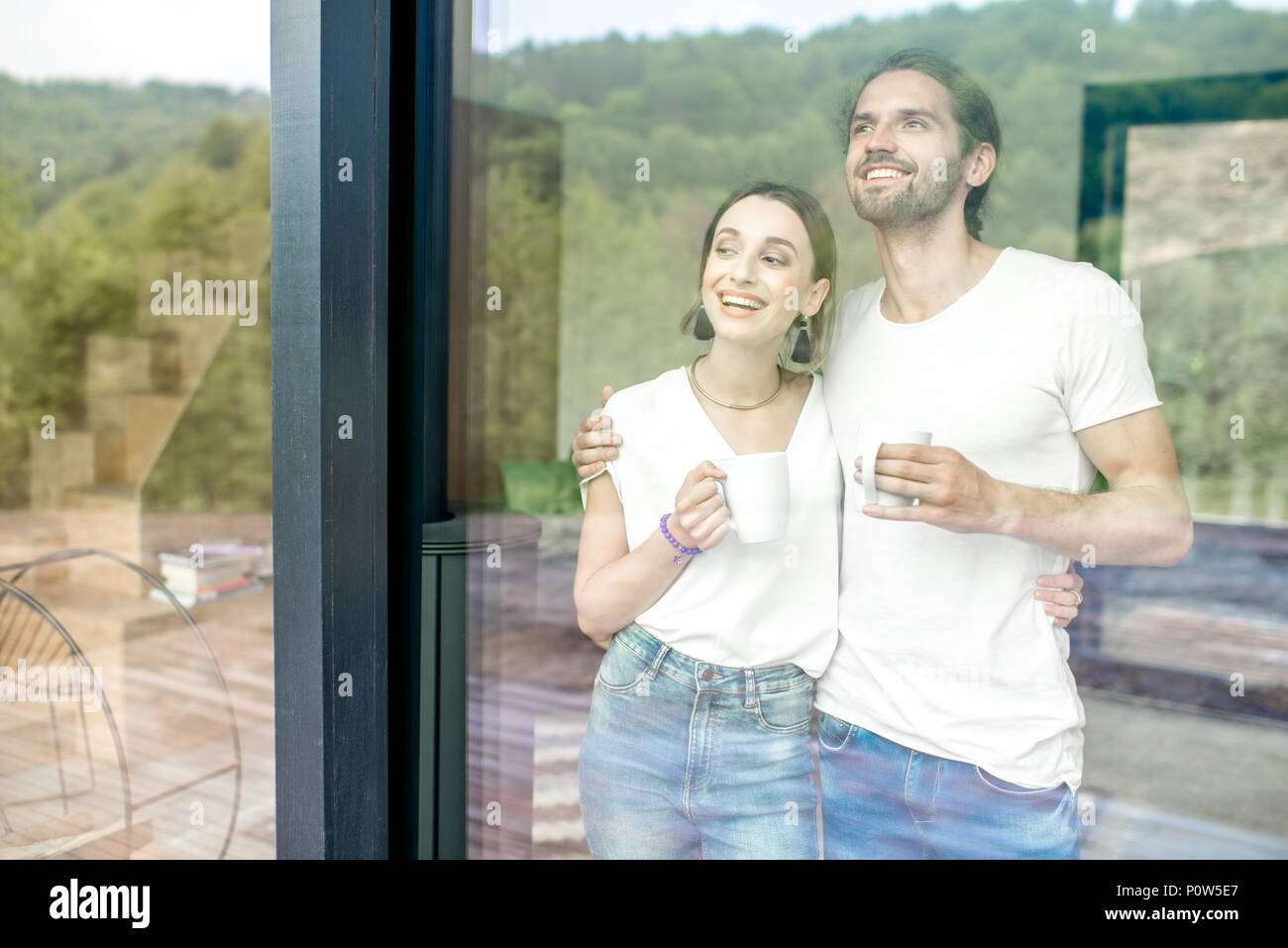 Couple looking outside the window Stock Photo - Alamy