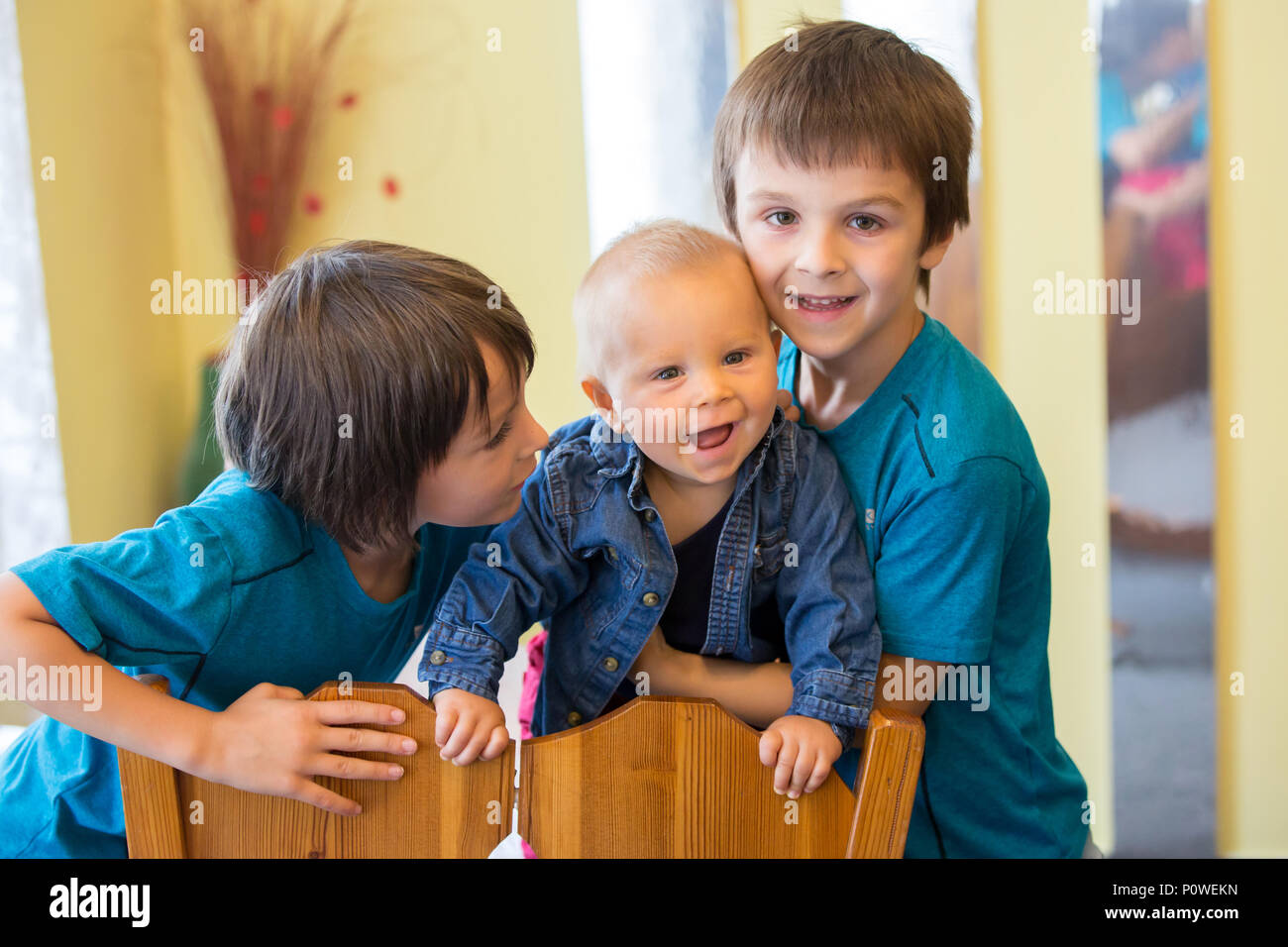 Two happy little preschool kids boys with baby boy brother in baby crib ...