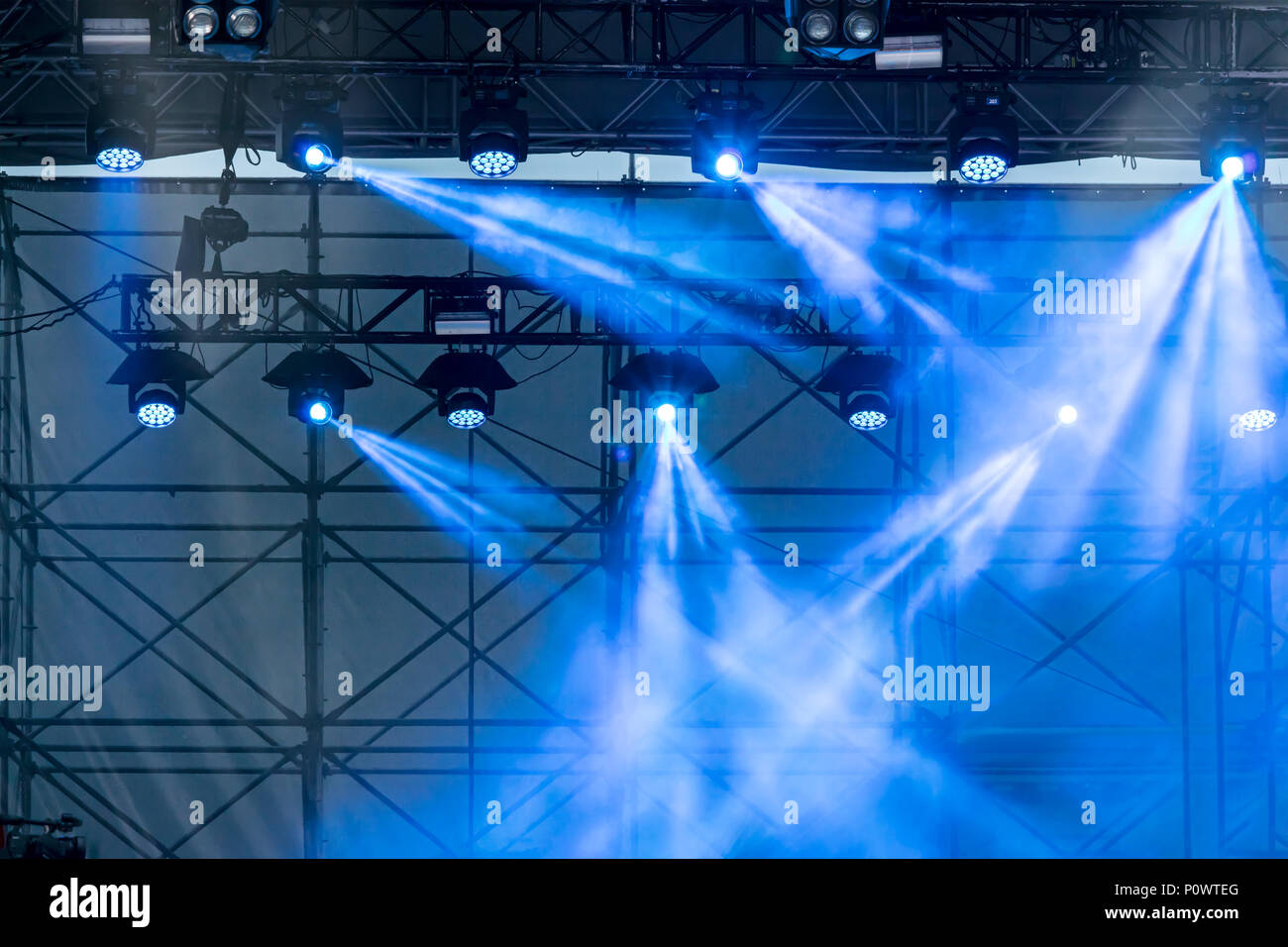 lights show during street concert. blue searchlights and smoke on the ...