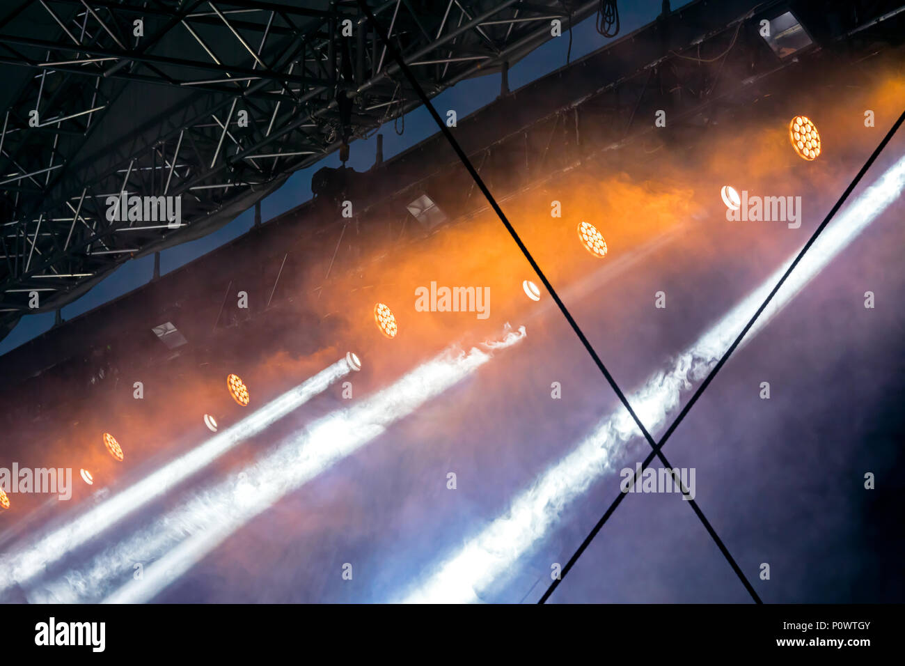 street concert scene, colorful spotlights shining through stage smoke ...