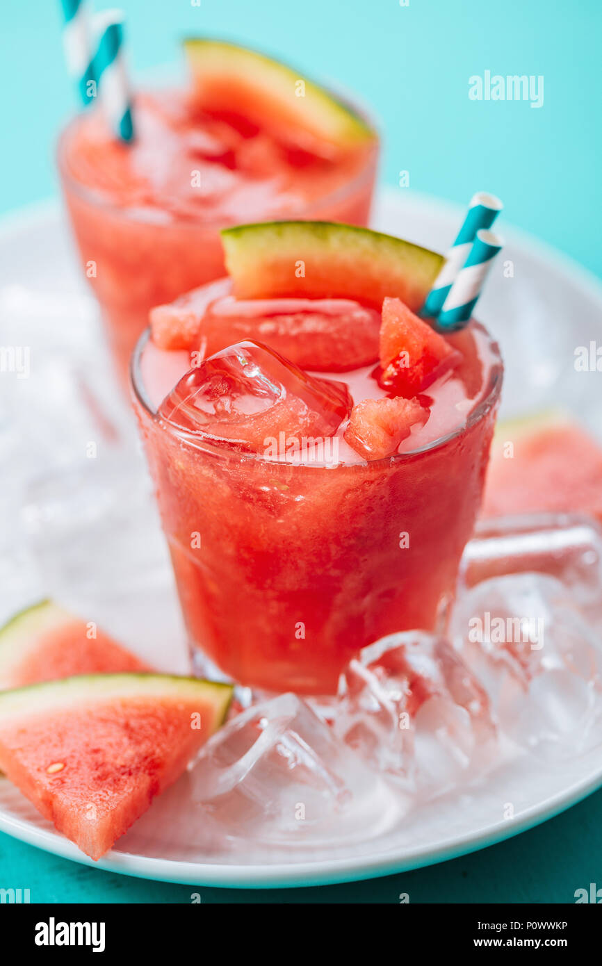 Fresh cold summer watermelon drink in glasses with ice on plate on blue ...