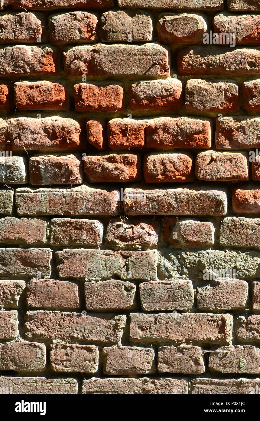 Vertical wall texture of several rows of very old brickwork made of red ...