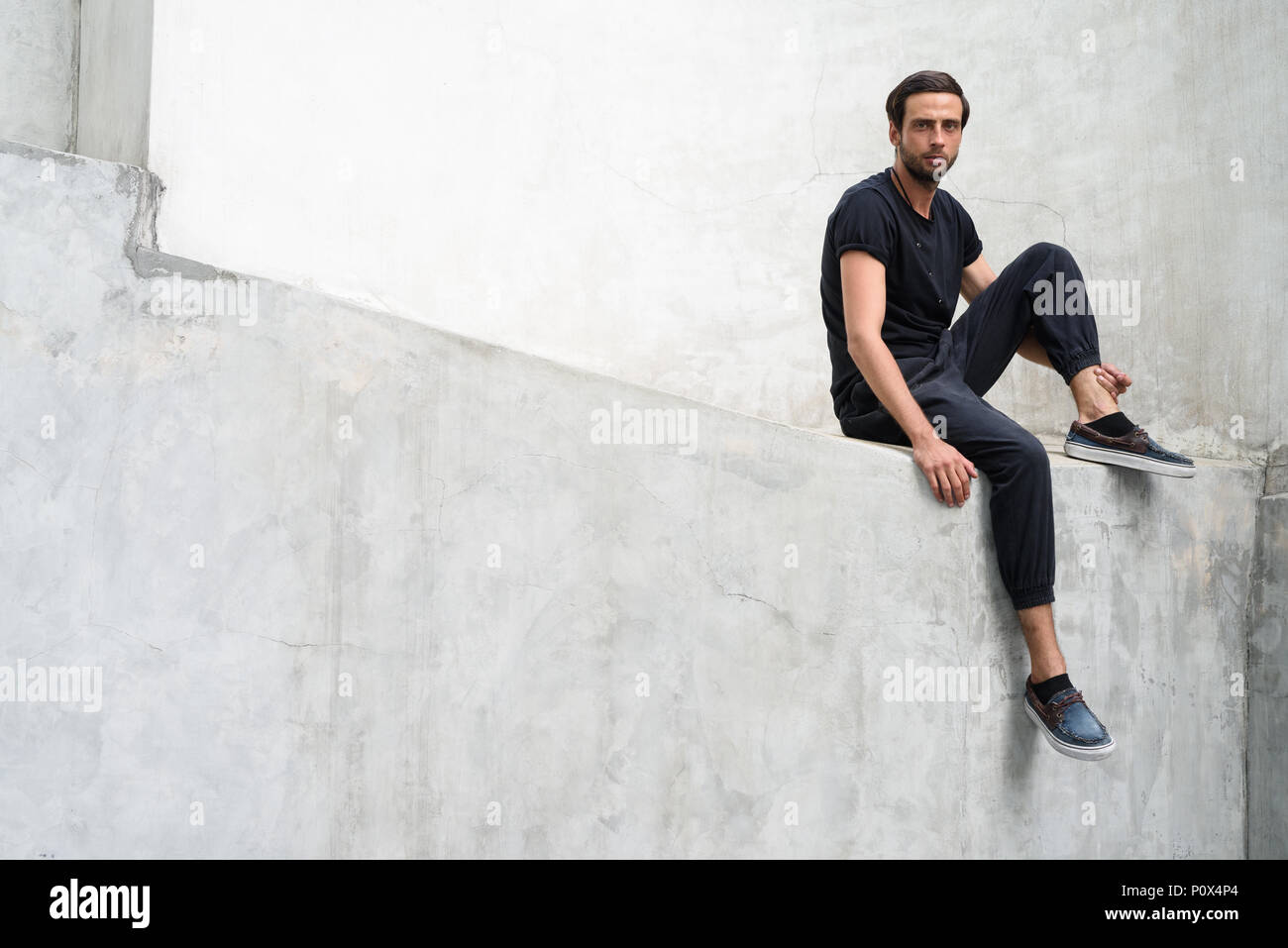 Man sitting against wall hi-res stock photography and images - Alamy