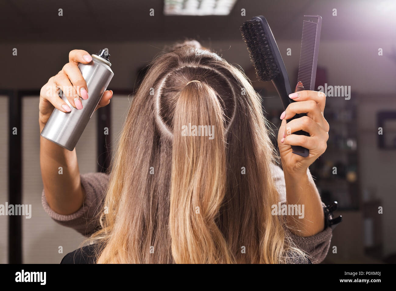 hairdresser fixing hairdo of a model with a hair spray Stock Photo - Alamy