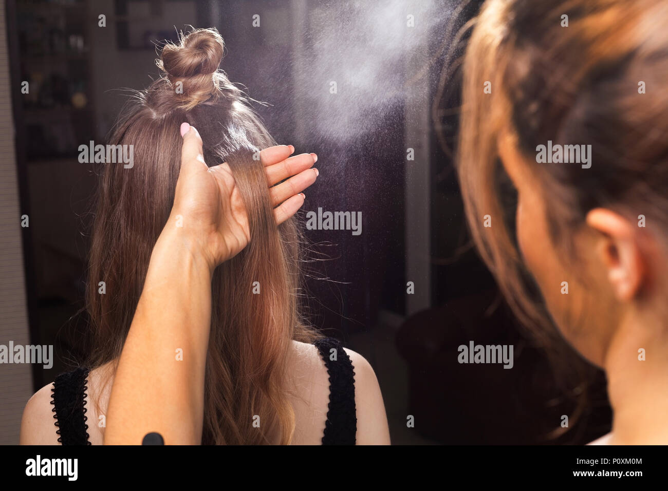 hairdresser fixing hair of a model with a hairspray Stock Photo - Alamy