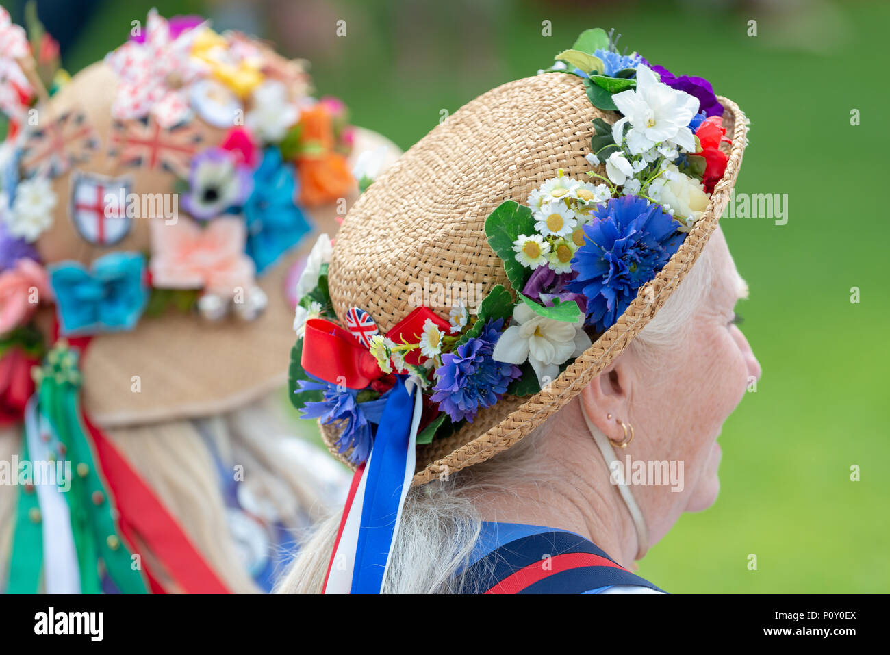 Female morris dancers wearing summer hats covered in colourful flowers ...