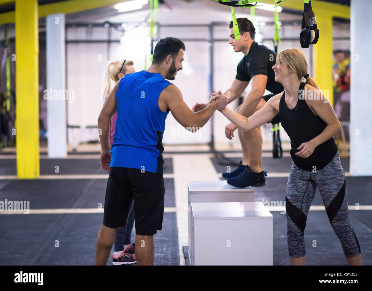 group of young healthy athletic people training jumping on fit box at ...