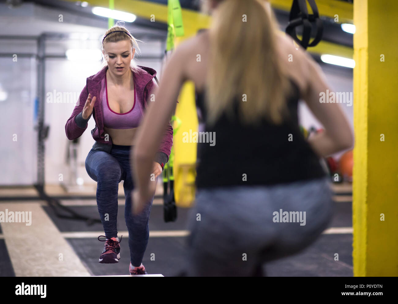 group of young healthy athletic people training jumping on fit box at ...