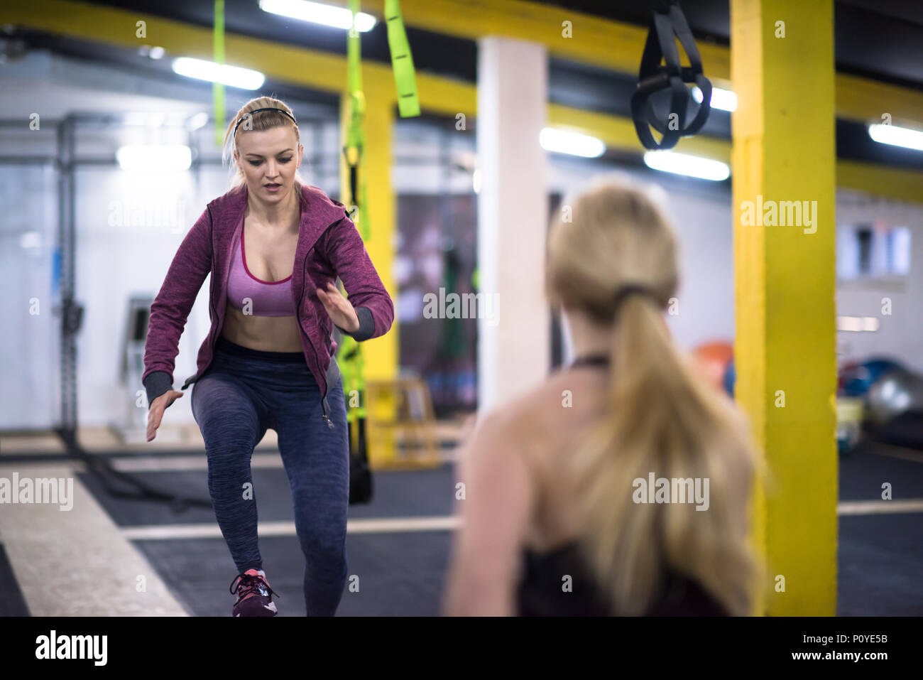 group of young healthy athletic people training jumping on fit box at ...
