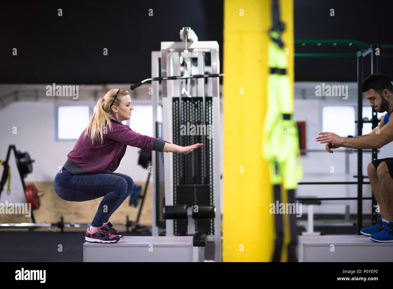 group of young healthy athletic people training jumping on fit box at ...