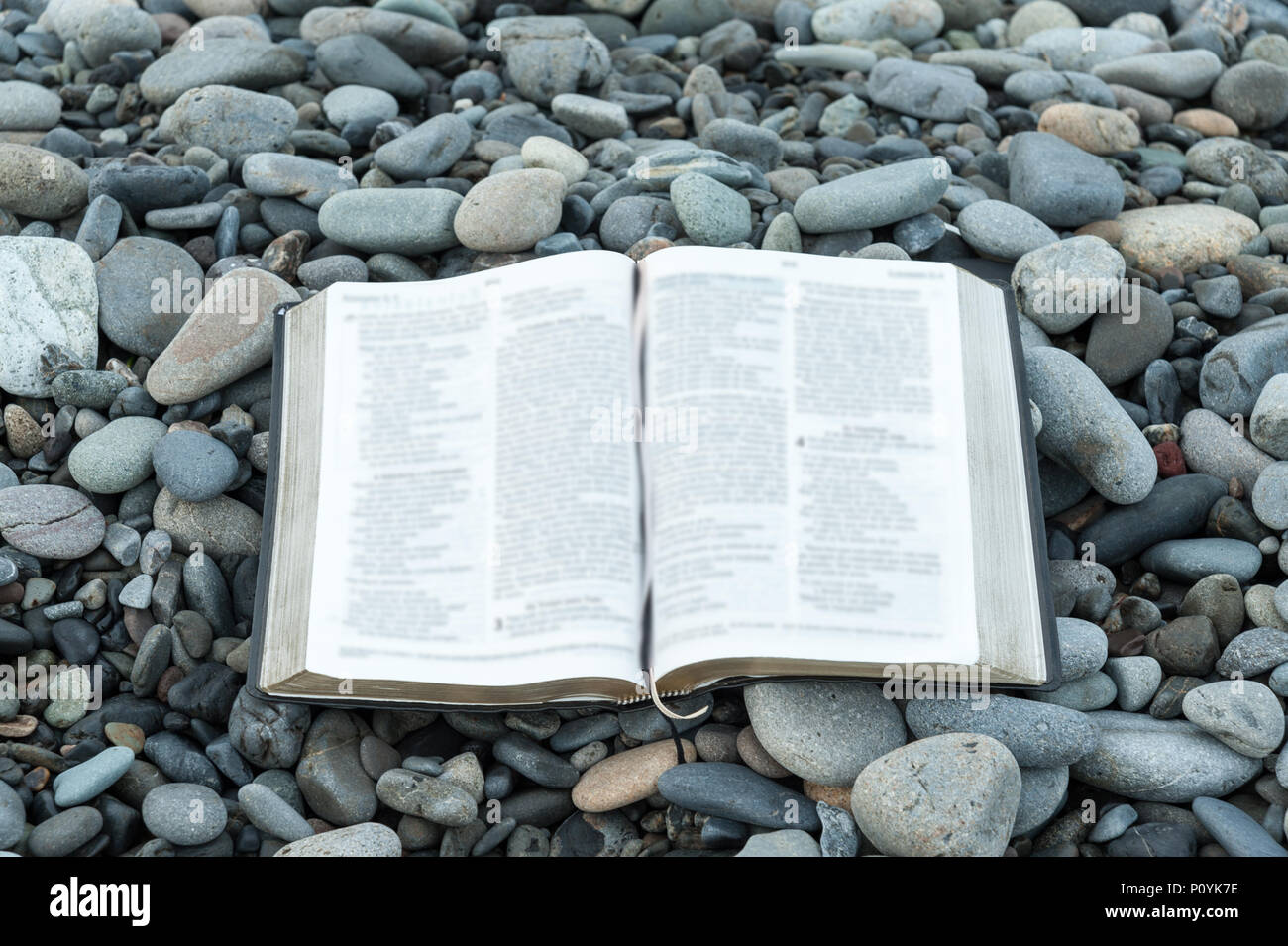 Open Bible on top of small stones. Close-up Stock Photo - Alamy