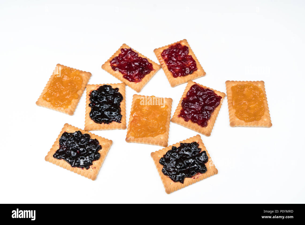 Some dry biscuits with jam on a white surface Stock Photo - Alamy