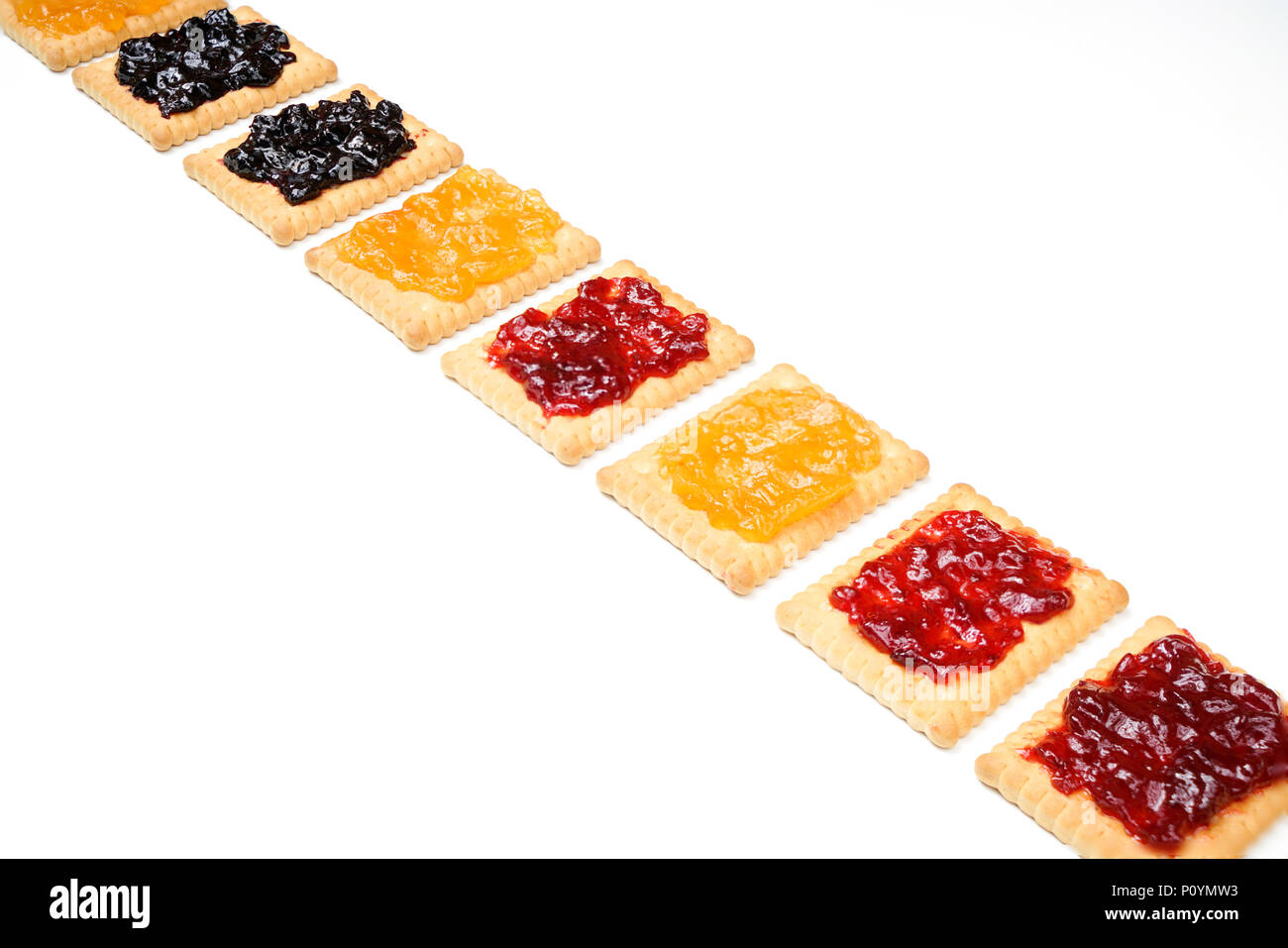 Some dry biscuits with jam on a white surface Stock Photo - Alamy