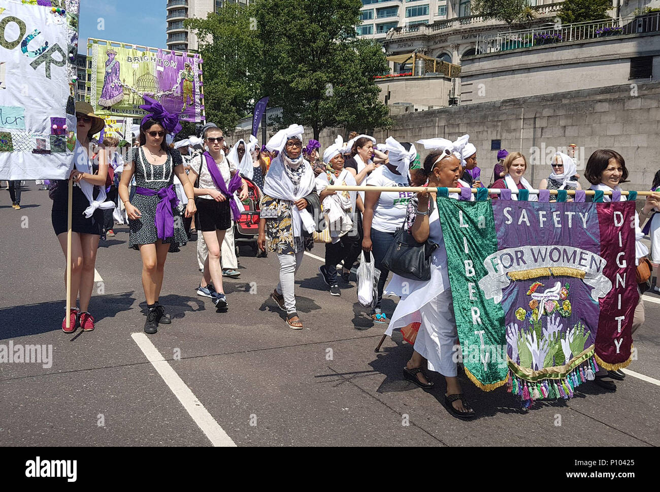 An artwork banner being held up, as thousands of people march through ...