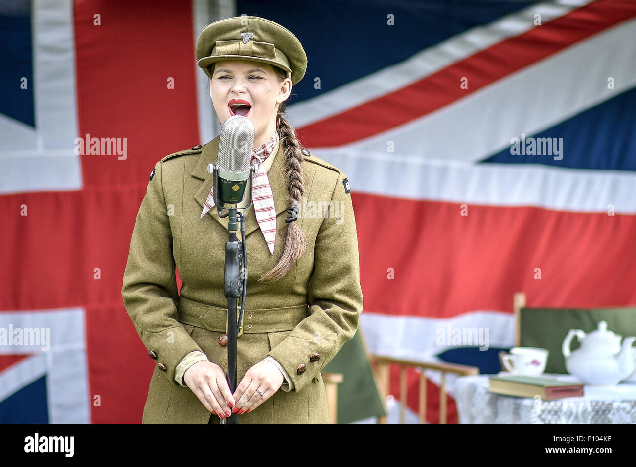 A woman wearing a WWII uniform sings wartime songs at the Dig for ...