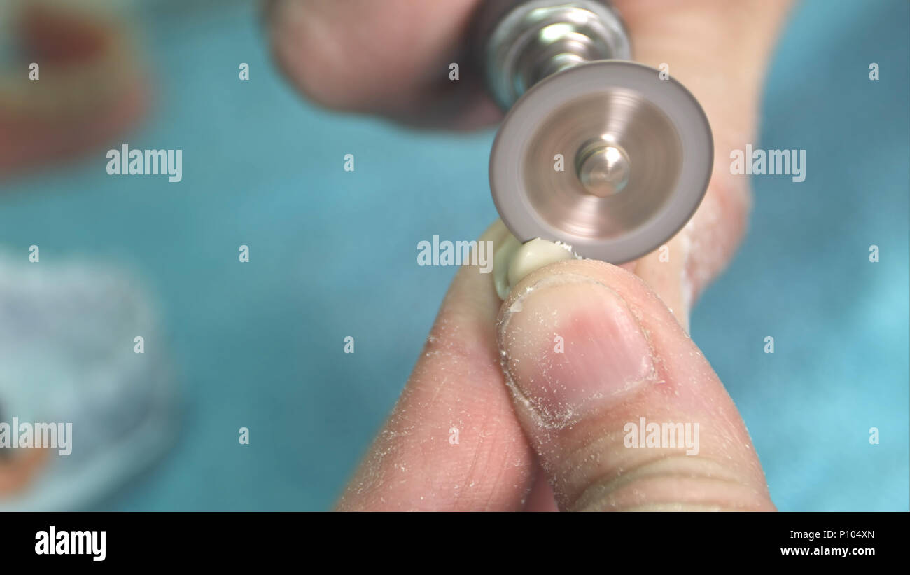 Lab technician cut dental prothesis Stock Photo - Alamy