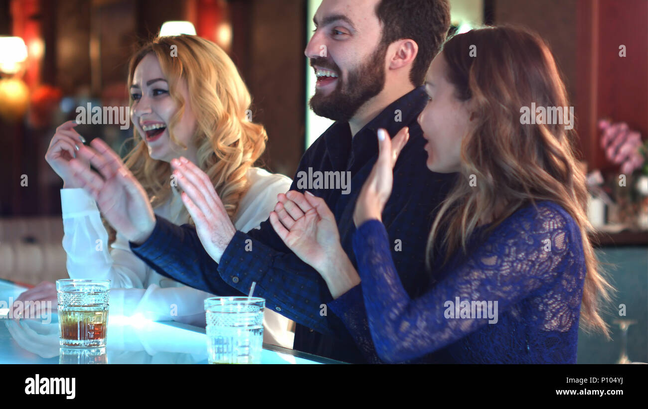 Happy and attractive group of friends chatting and laughing together in ...