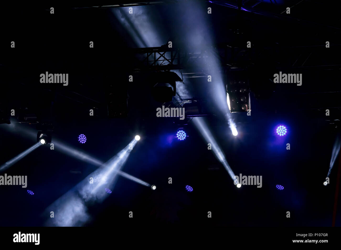 blue lights of projectors and searchlights over dark stage ...