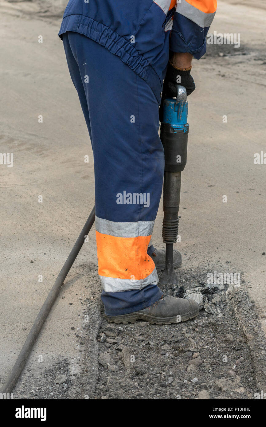 repair of roads. the worker is repairing the road Stock Photo - Alamy