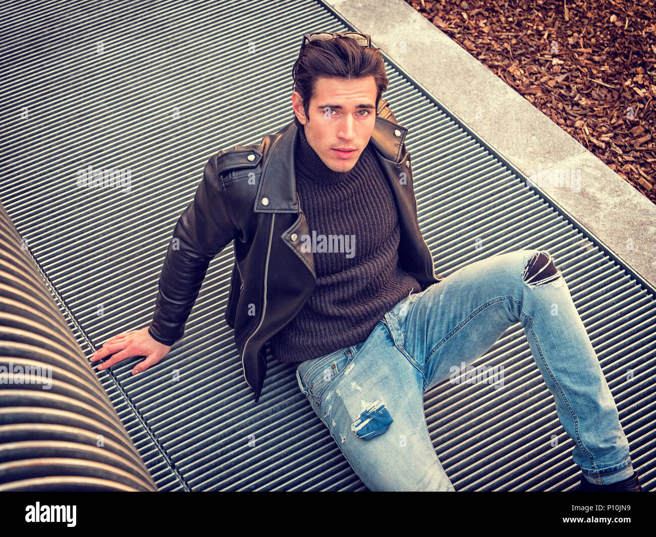 Young man on metal grid looking at camera Stock Photo - Alamy