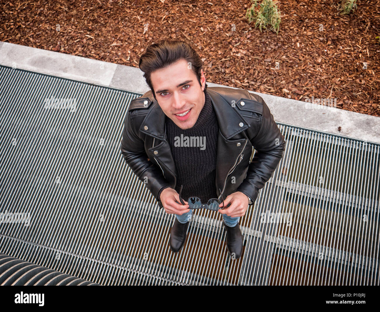Young man on metal grid looking at camera Stock Photo - Alamy
