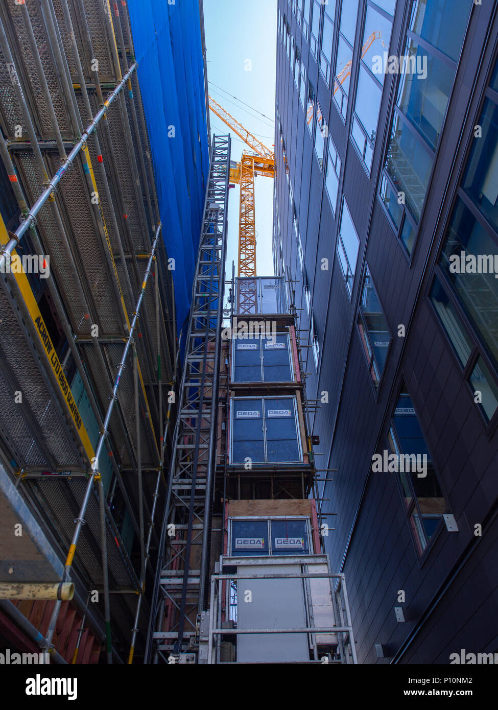 Cranstruction Crane In Between City Buildings Stock Photo - Alamy