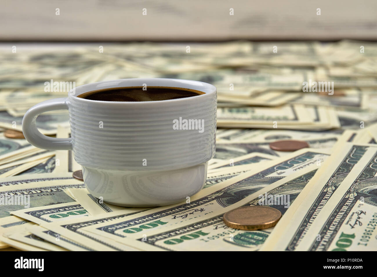 Coffee on dollar bills pile. Heap of money and coins Stock Photo - Alamy