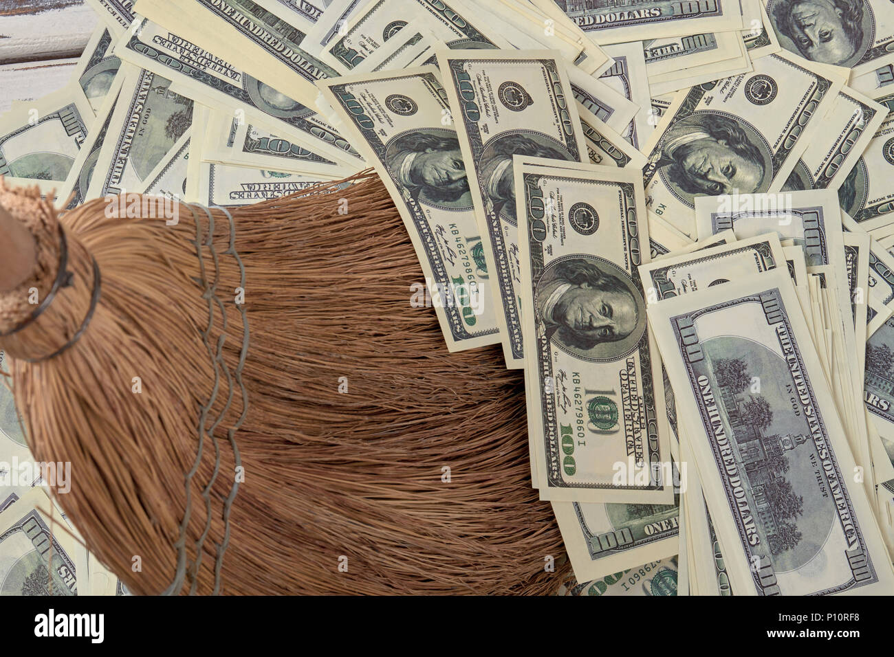 Money as garbage concept. Broom sweeps pile of dollars Stock Photo - Alamy