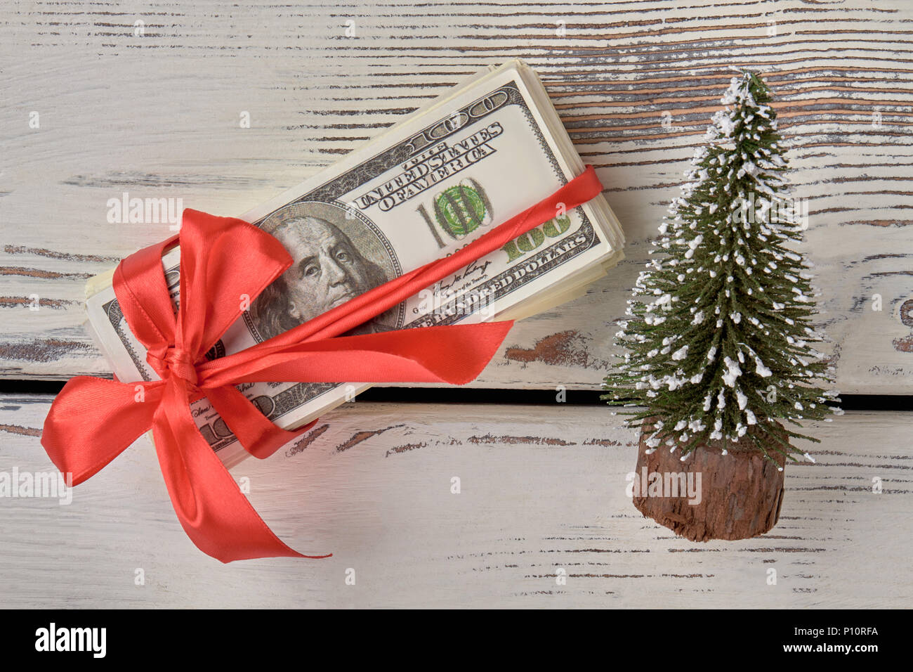 Christmas money gift concept. Dollars with red ribbon bow. White wood ...