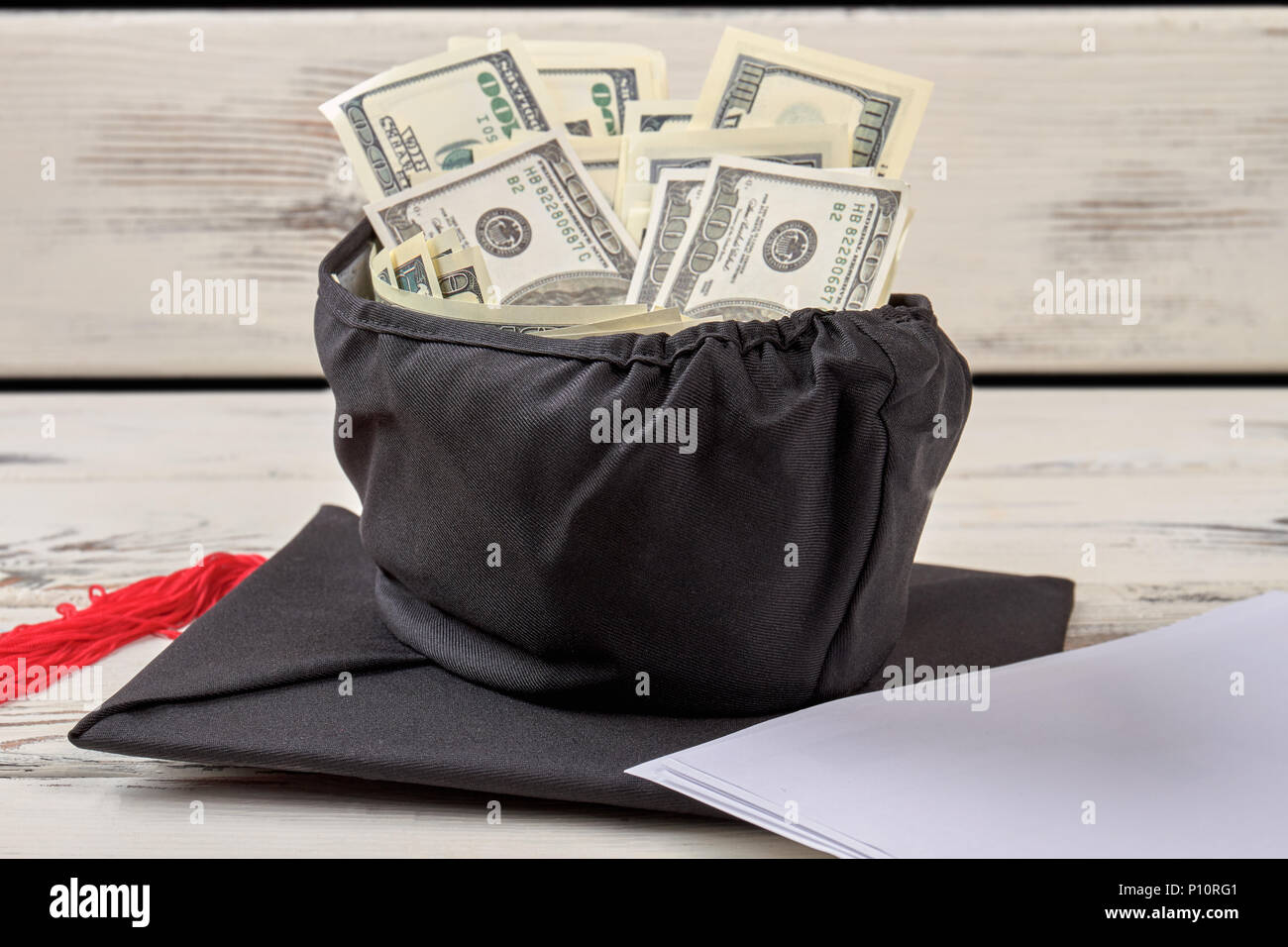 Bachelor degree hat full of money. Black bachelor cap with dollars ...