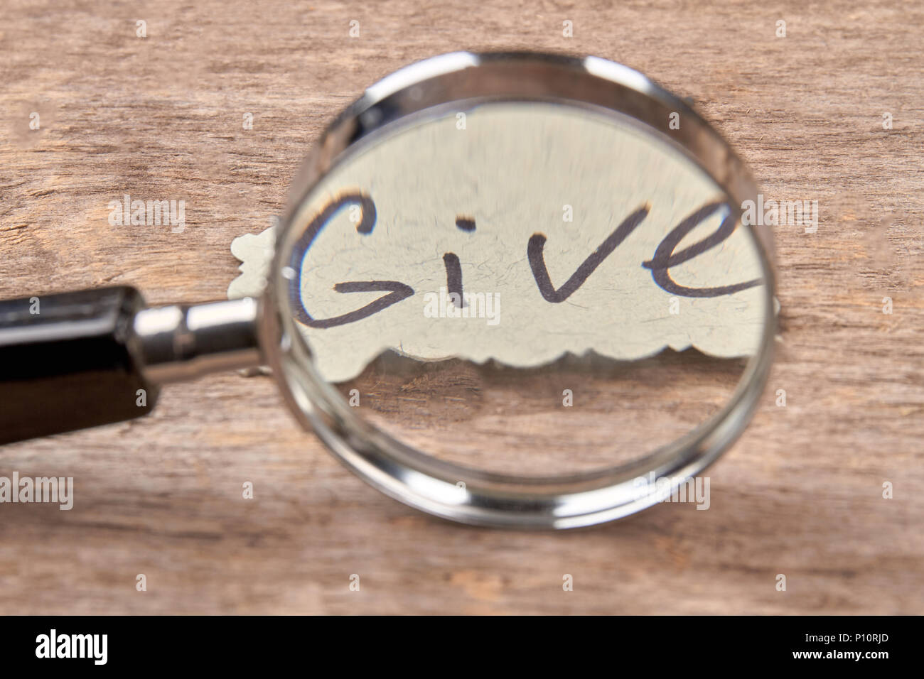 Magnifying glass zooming give word. Close up. Wooden background Stock ...