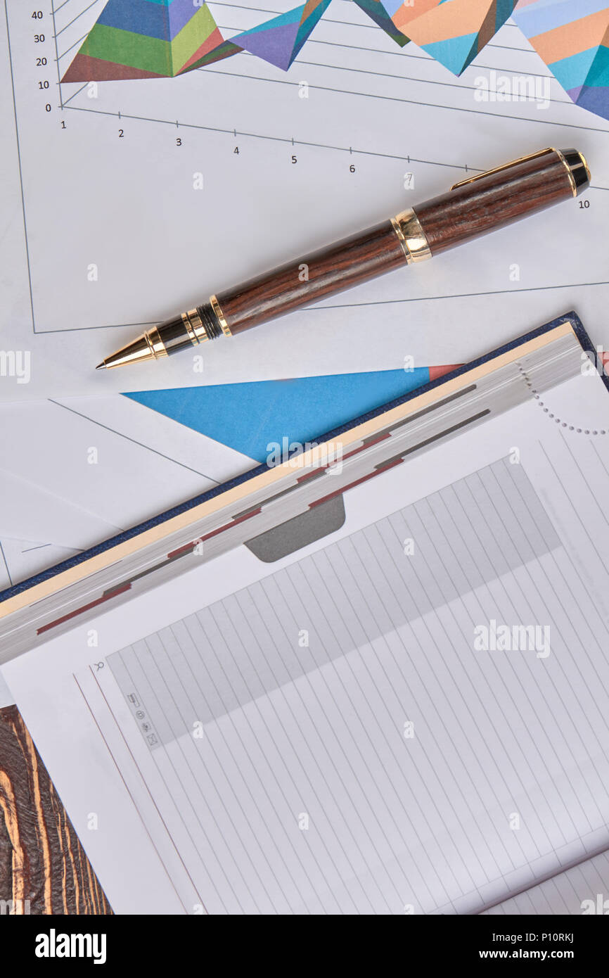 Finance and accounting concept. Notepad diary, papers with diagrams and ...