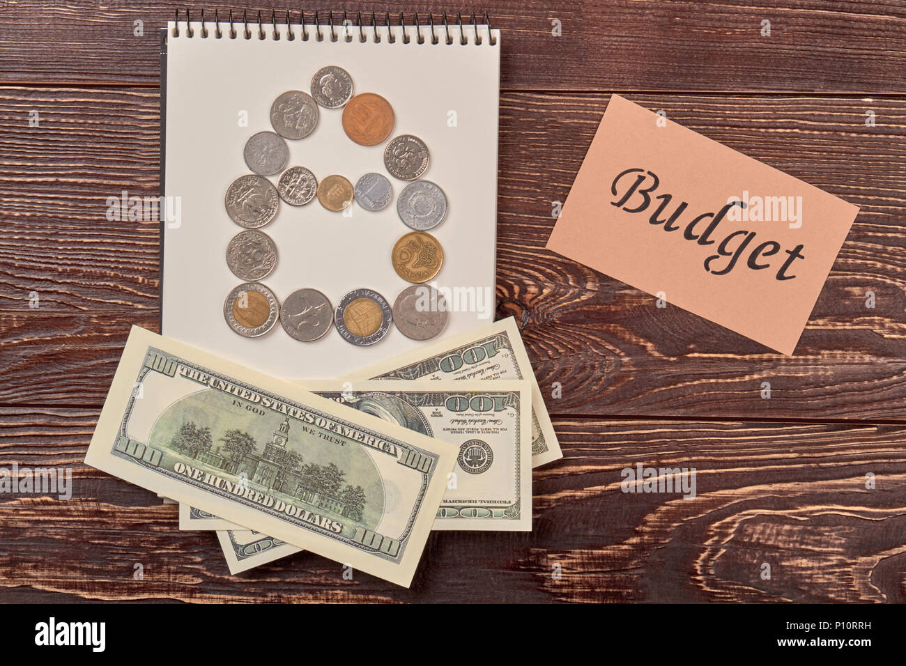 Budget concept, saving money. Notepad, dollars and coins Stock Photo ...