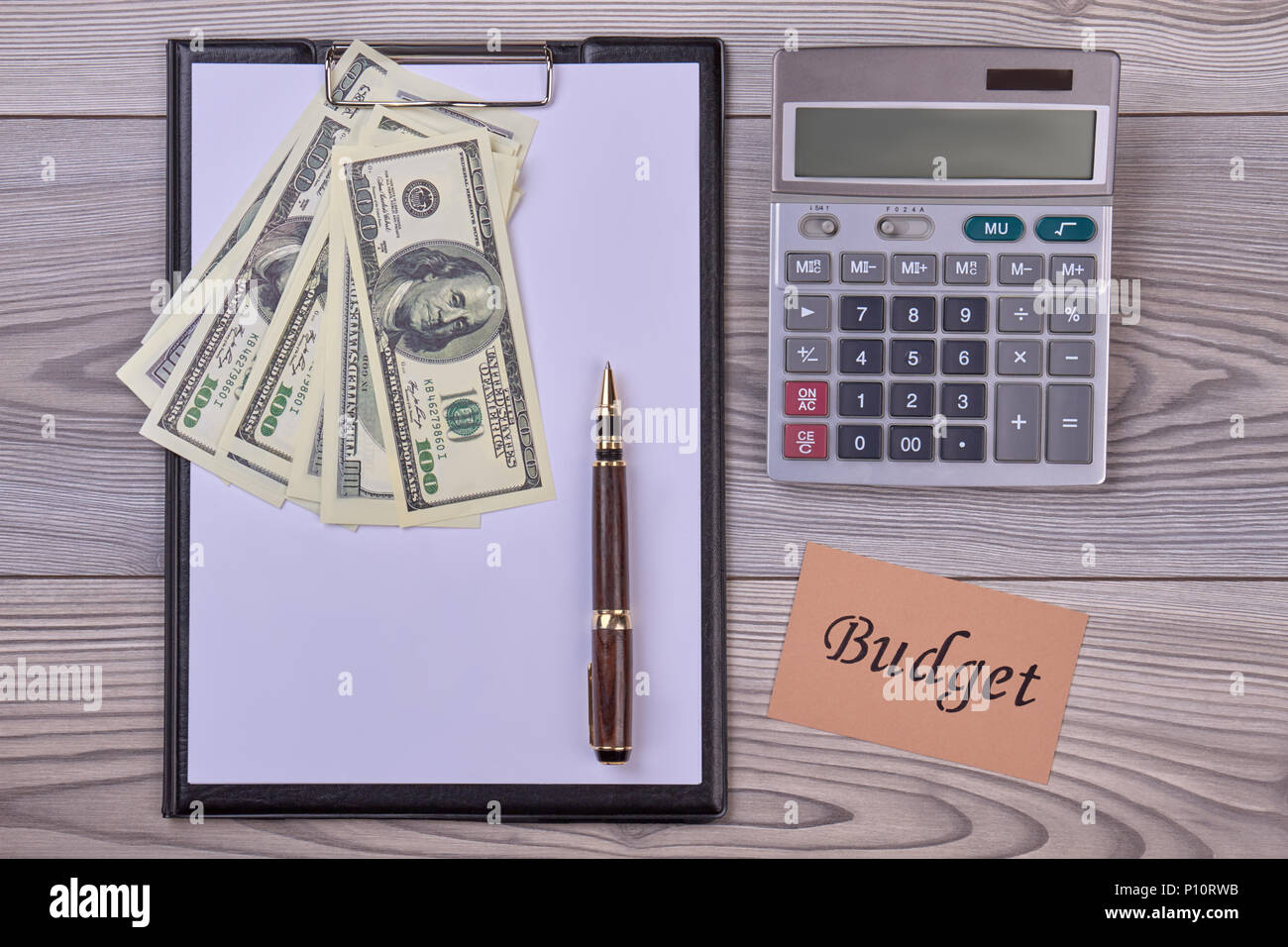 Budget accounting concept. Notepad, money, calculator and wood table ...