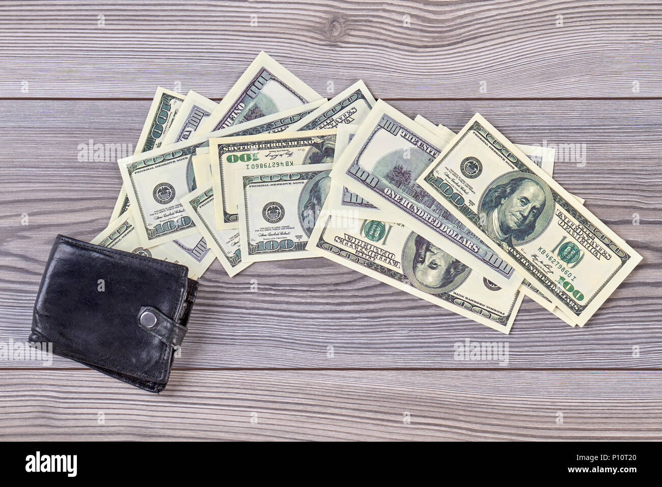 Black wallet and money. Pile of dollar cash. Wooden desk background ...