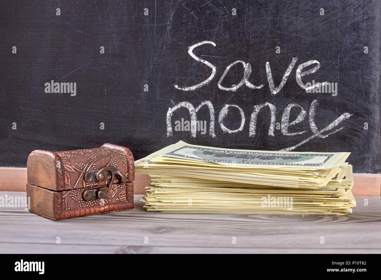 Stack of dollars and tiny chest moneybox. Save money concept. Black ...