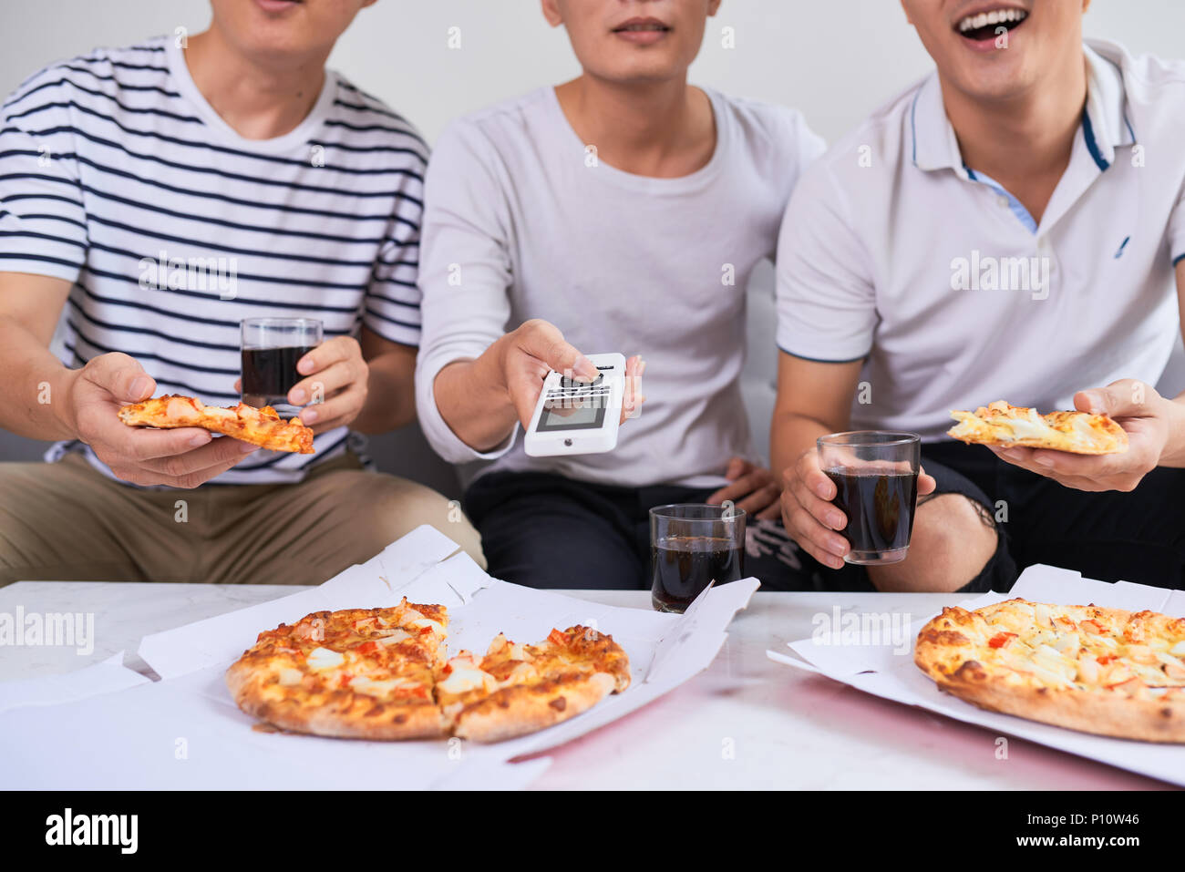 Positive joyful friends enjoying their pizza Stock Photo - Alamy