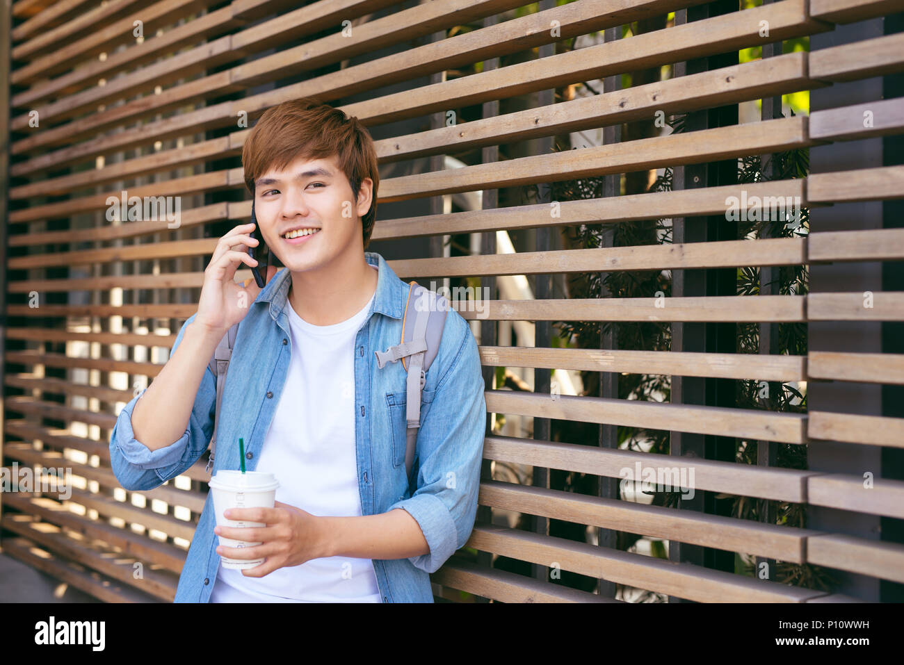 Stylish young man standing in the street and talking on the phone Stock ...